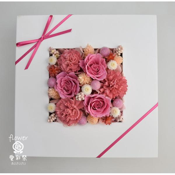 縦18cm　横18cm　フレームのみの厚さ5cm正方形のフレームの真ん中にお花をアレンジしました。プリザーブドフラワーのピンクのバラにピンクのソーラーカーネーション、ピンクと白の小花の組み合わせです。斜めに掛けたリボンもかわいいです。フレー...