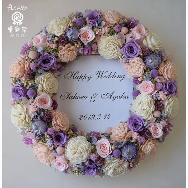 27cm＜ベース　スポンジ　25cm＞紫とピンクのバラ、白とピンクのソーラーフラワープリザーブドフラワーのウェルカムリースです。バラをたっぷり使って華やかな仕上がりです。プレートにお入れする文字は、サンプルを参考にメッセージ欄またはご要望欄...