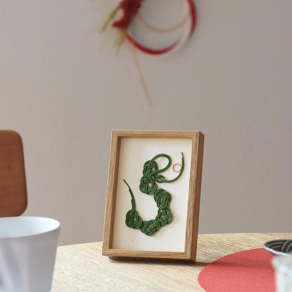 水引手仕事ブランド「hare」のお正月フレーム（巳）。躍動感のある巳の姿を縁起の良いあわじ結びで結んだ一品です。天然木フレームでお家にも馴染みやすいデザイン。