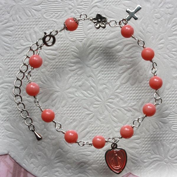 半貴石白珊瑚を使用（ピンク染：染め加工が施されているため、汗や濡れなどにより色落ちをする場合がございます）不思議のメダイはハート型。しかもピンク(^-^)お花パーツはシルバーカラー長さ：約１７センチチャームはイタリア製