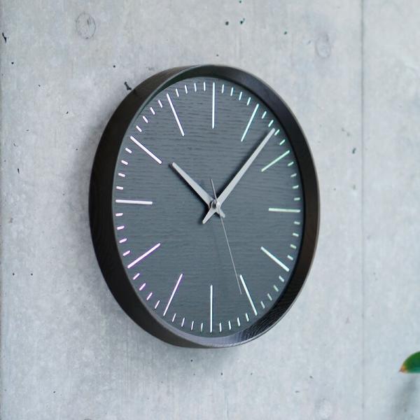 レムノスの掛け時計壁掛け時計に、より品格を。Fluctは品格をテーマに、素材と質感表現に主眼を置き、あらゆる細部まで徹底的にデザインされた壁掛け時計です。枠と文字盤の天然木材による柔らかで優しい表情、象嵌のような特徴的な鏡面仕上げのインデッ...