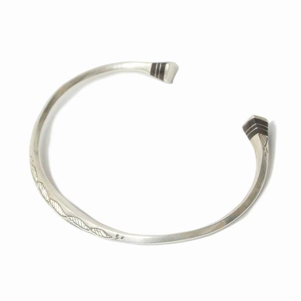 TUAREG SILVER JEWELRY【トゥアレグ シルバー ジュエリー】のバングル。フリーサイズです。鏨(たがね)という特殊な道具で一点一点彫を入れて作られています。男女問わずお使い頂けます。中央が太くなっており先端に独特な意匠がほら...