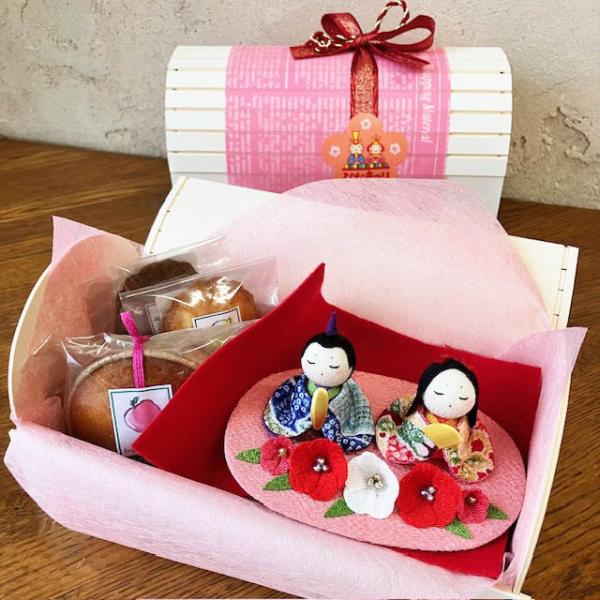 ドーム型のボックスに、ちりめんの雛人形と焼き菓子5個を詰め合わせたかわいいひな菓子ギフト。ラッピングもピンクのリボンでかわいく仕上げました。ちりめんを貼り合わせて作られたのおひな様と内裏様。おなじくちりめんの花をあしらったピンクの台にちょこ...