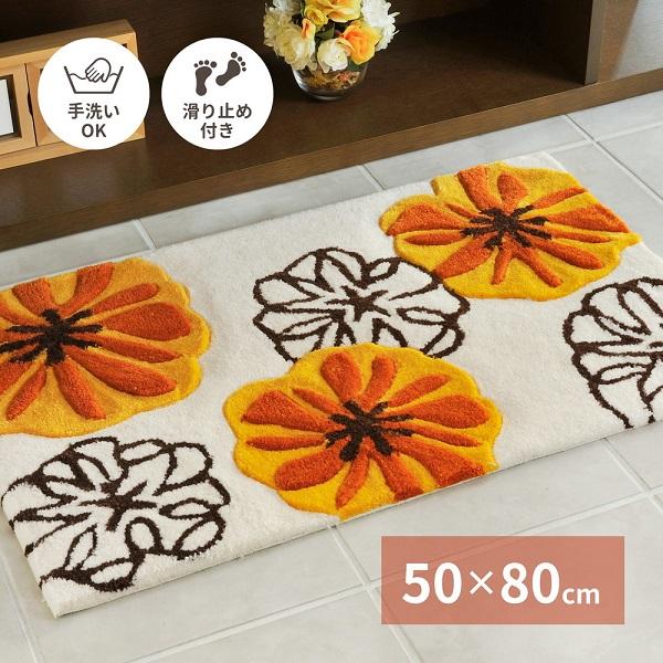 【発売日：2022年11月09日】玄関マット　マリア　約50×80cm アイボリー地にひときわ目立つオレンジの花を咲かせました。あなたのお帰りを元気いっぱいに迎えてくれる、そんな玄関マットです。最長約12mmのパイル長と打ち込みもよく、足あ...