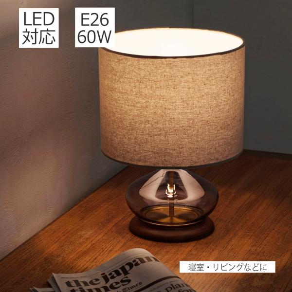 異なる素材をバランスよくまとめた、クラシカルなテーブルライト。くびれたブルーグレーのガラスと、ウッドベースが作るプロポーションにゴールドが映える、シックな佇まいです。ファブリックシェードを通して広がる光が、お部屋を優しく包み込みます。※電球...