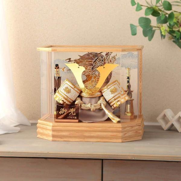 【2026年度新作五月人形】 宝童監修「白金中鍬兜」8号六角ケース飾りです。大きく力強い鍬形が印象的な兜は、白と金を基調に仕立てられており、気品あふれる仕上がりに。鉢や吹返しにデザインされた細やかな牡丹の意匠も目を引きますね。木目を生かして...