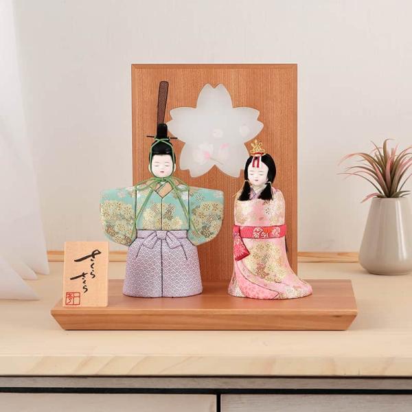 【2026年度新作雛人形】【江戸木目込人形 一秀】 毎年早期完売多数の一秀の「さくらさくら」シリーズから、コンパクトサイズの親王飾りのご紹介です。自然の風合い豊かな飾り台と衝立に、雛人形のルーツといわれる伝統的なスタイルである立雛をあわせま...