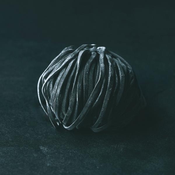 イカスミをふんだんに練り込んだタリオリーニ。歯切れが良くトマトソースやオイルソースと相性抜群です。見た目は真っ黒ですがイカスミはしっかり練り込まれているので、歯が黒くなる心配もありません。思う存分、イカスミパスタをお楽しみください。----...