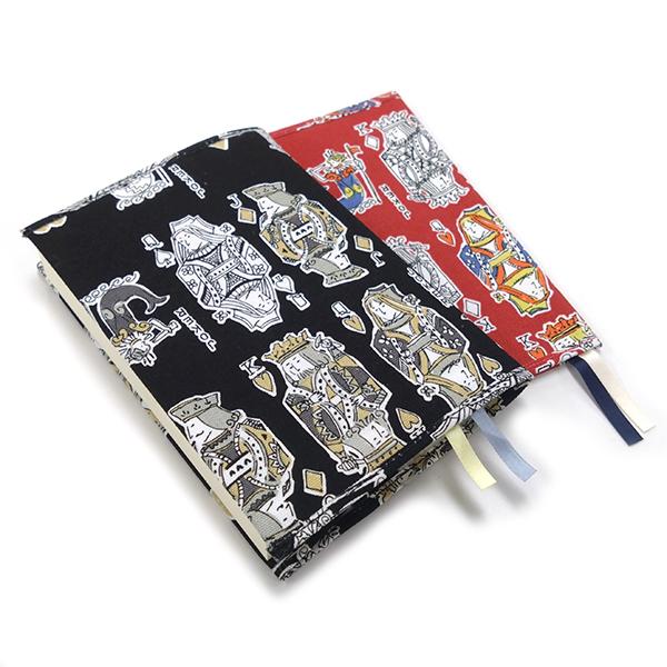 スロット柄の布ブックカバー。内側はPVC加工を施しているので、汚れや水滴から本を守ります。折り返して背表紙の厚みによって調整が可能です。2本のしおり紐付き。素材：綿生産：日本調整幅：1〜3cm程度の背幅に対応使用上の注意：洗濯はできません。...