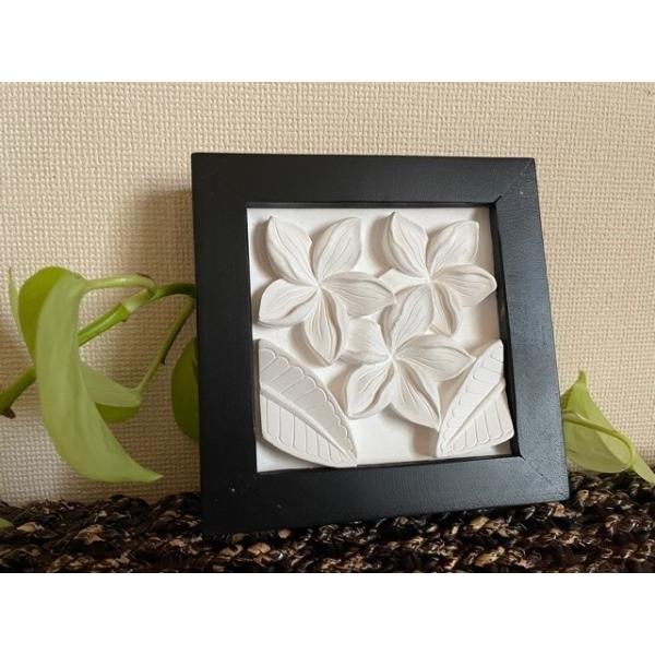 プルメリアやバナナの葉っぱの彫刻がかわいらしいレリーフ黒いウッドのフレームが白い壁によく映えますフレームサイズ　１３ｃｍｘ１３ｃｍ　奥行約３ｃｍ