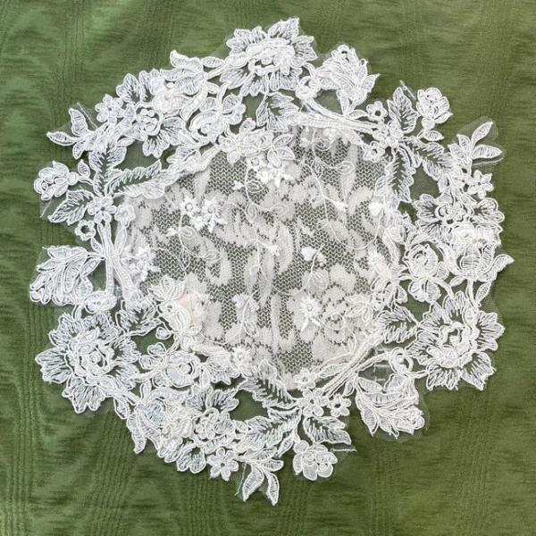 オフホワイトのローズ刺繍が贅沢なチュールレースで天使の羽根のような輝きを見せる優美なドイリー。小さな透明のスパンコールが散りばめられていてキラキラと品よく光を放つラグジュアリーな仕上がりです。■サイズ：直径約30cm■素材：ポリエステル10...