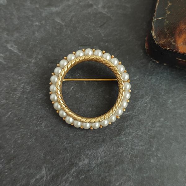 ■size幅3.5cm　厚さ0.5cmコスチュームジュエリー界で最も著名なTRIFARIのヴィンテージブローチ。ゴールドトーンのロープ状フレームに、艶やかなパール調ビーズをぐるりと一周配した、気品のあるラウンドデザインです。立体感のあるツイ...