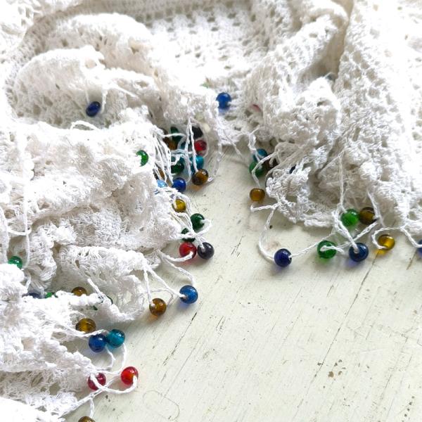 ■size幅=61cm×40cm（ビーズを含む時65cm×44cm）細いコットンの糸で編んだ長方形のクロシェレースの周囲を色とりどりのガラスビーズで飾ったテーブルマットです。イギリスで見るガラスビーズのドイリーは殆どが円形の小さめサイズのジ...