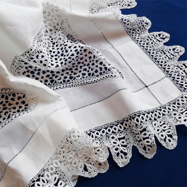 ■size幅=102cm角周囲のレース幅=8cm張りのあるリネン地に角の無い三角形のようなクロシェレースのパーツを四箇所に入れたテーブルクロスです。クロシェレースは細いレース糸で丁寧に編まれています。縁周りの飾りレースは植物にも見えて、輪っ...