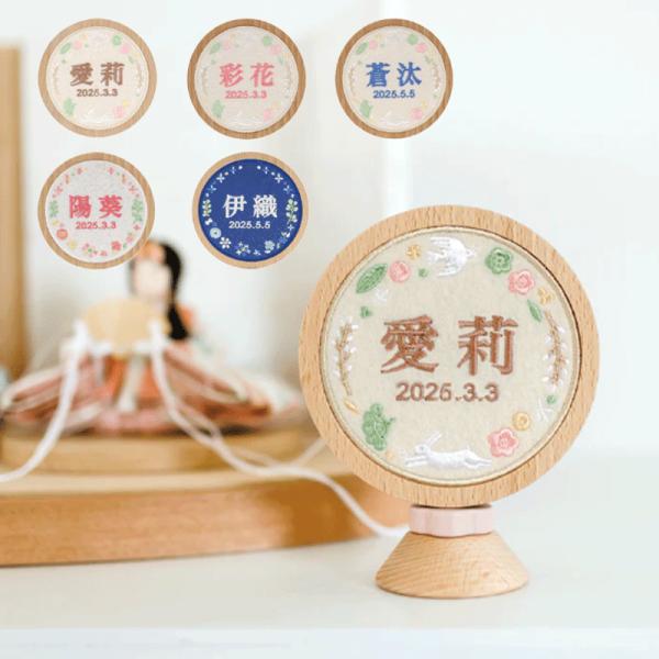 サイズ・素材商品サイズ【飾った時のサイズ】H145×W115×D60ｍｍ【箱サイズ】H28×W269×D183mm素材 台：ブナ材刺繍：ポリエステル糸：レーヨン糸プーカの刺繍お名前飾り「くるくる」は、華やかなオリジナルの刺繍とくるくる回るコ...