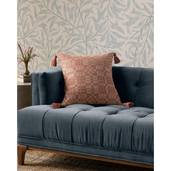 ・The Ellery throw pillow features a geometric pattern in a muted clay tone with tasseled corners; designed by Chris Love...