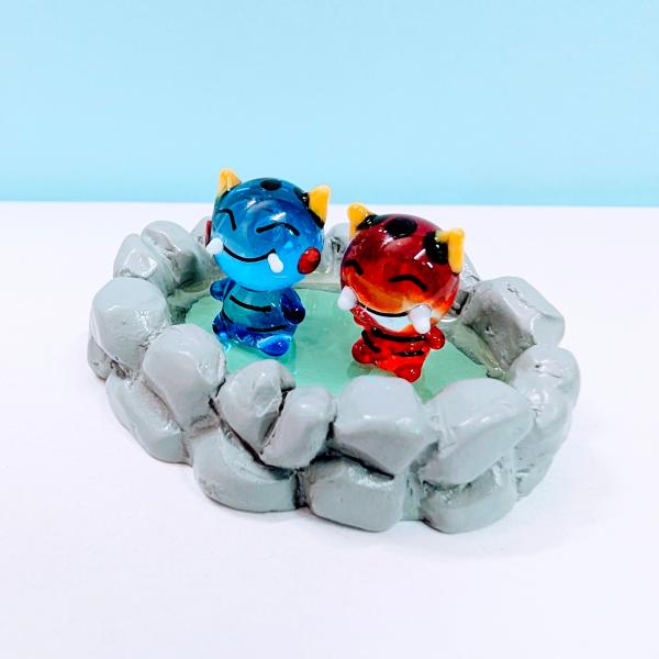 温泉鬼ペアのガラス細工の置物です。温泉はポリ製です。【大きさ】約高さ２０ミリ　　横幅４６ミリ　　　　　奥行３７ミリ＊商品は一つ一つ手造りのため大きさや色合いなどが写真と異なる場合がありますのでご了承をお願い致します。