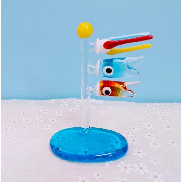 鯉のぼり（青のステージ付）のガラス細工の置物です。【大きさ】約高さ６８ミリ　　横幅４５ミリ　　　　　奥行２６ミリ＊商品は一つ一つ手造りのため大きさや色合いなどが写真と異なる場合がありますのでご了承をお願い致します。