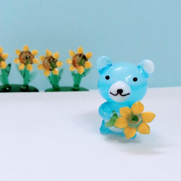 クマ（青）とひまわりのガラス細工の置物です。【大きさ】約高さ２５ミリ　　横幅１８ミリ　　　　　奥行２０ミリ＊商品は一つ一つ手造りのため大きさや色合いなどが写真と異なる場合がありますのでご了承をお願い致します。