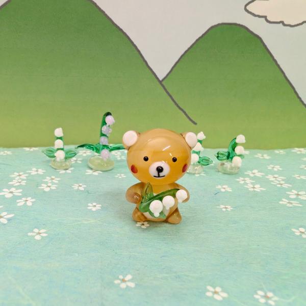 クマスズラン持ちのガラス細工の置物です。　【大きさ】約高さ２５ミリ　　横幅２０ミリ　　　　　奥行２０ミリ＊商品は一つ一つ手造りのため大きさや色合いなどが写真と異なる場合がありますのでご了承をお願い致します。
