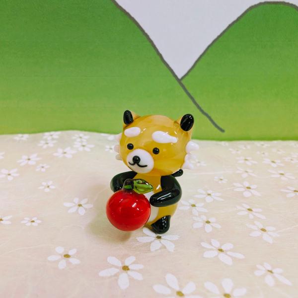 レッサーパンダとリンゴのガラス細工の置物です。【大きさ】約高さ２５ミリ　　横幅１８ミリ　　　　　奥行２５ミリ＊商品は一つ一つ手造りのため大きさや色合いなどが写真と異なる場合がありますのでご了承をお願い致します。
