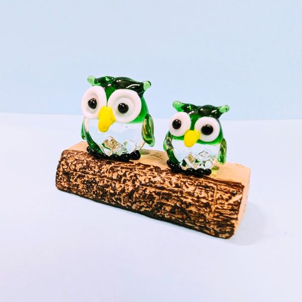 ふくろう2人ベンチ（木台）緑のガラス細工の置物です。木台はポリ製です。【大きさ】約高さ２５ミリ　　横幅４０ミリ　　　　　奥行１８ミリ＊商品は一つ一つ手造りのため大きさや色合いなどが写真と異なる場合がありますのでご了承をお願い致します。