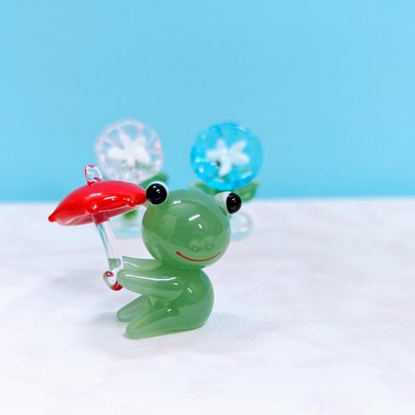 カエル（横）と傘のガラス細工の置物です。【大きさ】約高さ３０ミリ　　横幅２８ミリ　　　　　奥行１５ミリ＊商品は一つ一つ手造りのため大きさや色合いなどが写真と異なる場合がありますのでご了承をお願い致します。