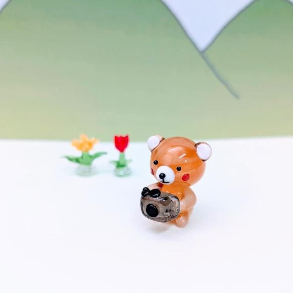 クマとカメラのガラス細工の置物です。【大きさ】約高さ２５ミリ　　横幅２０ミリ　　　　　奥行２５ミリ＊商品は一つ一つ手造りのため大きさや色合いなどが写真と異なる場合がありますのでご了承をお願い致します。