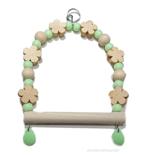 お花型のウッドビーズと淡い色合いのビーズのナチュラル系カラーブランコです。グリーンは枝豆のような優しい色♪材質：ステンレス金具、止まり木、ウッドビーズ、アクリルビーズ サイズ：止まり木の幅　約１１ｃｍ、全体の高さ　約１６ｃｍ