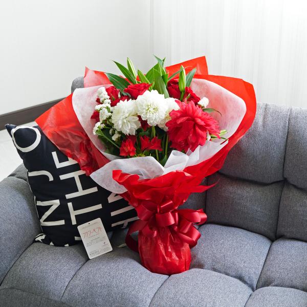 花束の前面はお花がよく見えるように大きく開いたボリューム感のある花束です。トロフィーなどに使用する名入れリボンと滲みにくいペン付きのため、受章者や当選者、登壇者様のお名前を入れていただけます。めでたい紅白カラーで大勢の方の前でのお渡しや、記...