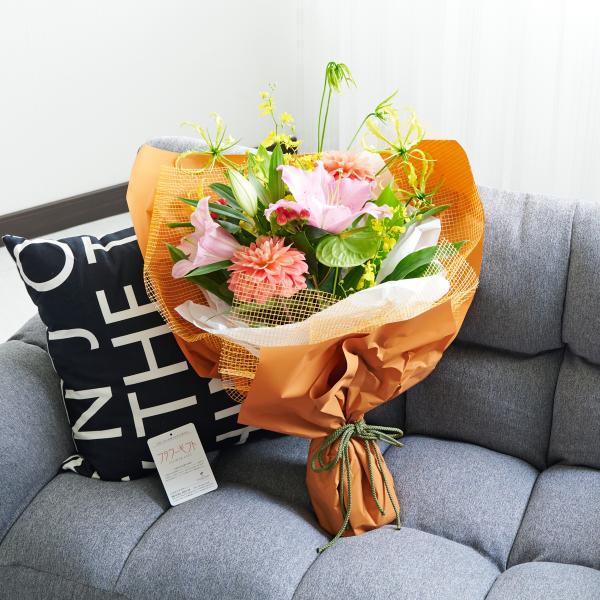 花束の前面はお花がよく見えるように大きく開いたボリューム感のある花束です。トロフィーなどに使用する名入れリボンと滲みにくいペン付きのため、受章者や当選者、登壇者様のお名前を入れていただけます。カラフルなミックスカラーで大勢の方の前でのお渡し...