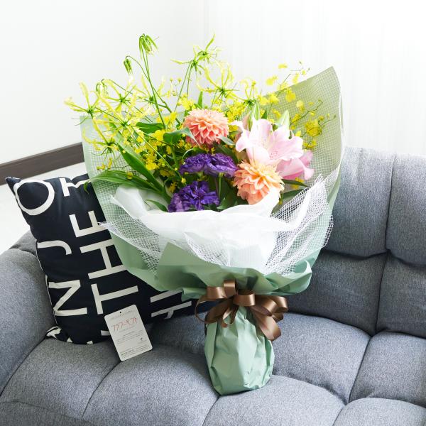 花束の前面はお花がよく見えるように大きく開いたボリューム感のある花束です。トロフィーなどに使用する名入れリボンと滲みにくいペン付きのため、受章者や当選者、登壇者様のお名前を入れていただけます。カラフルなミックスカラーで大勢の方の前でのお渡し...