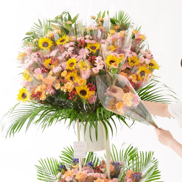 卒業式、発表会、結婚式、公演会、講演会、法人主催のレセプションパーティーなど、多くのゲストを招くお祝いの場を華やかに彩るスタンド花をご用意しました。通常のスタンド花とは異なりフィルムや包装紙で包んだ花束を寄せ集めた作品となっているので、招待...