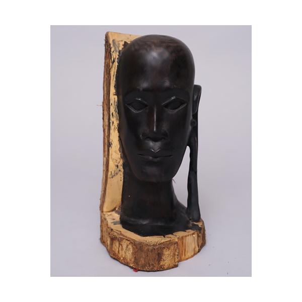 原産国:タンザニアサイズ:高さ約21cm東アフリカのマコンデ族に受け継がれる木彫技術によって生み出されたヘッドスカルプチャーです。着色に頼らず、木そのものが持つ芯の深い色合いと、外皮に近い明るい部分とのコントラストを活かすことで、静かな表情...