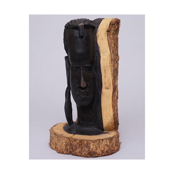 原産国:タンザニアサイズ:高さ約23cm東アフリカのマコンデ族に受け継がれる木彫技術によって生み出されたヘッドスカルプチャーです。着色に頼らず、木そのものが持つ芯の深い色合いと、外皮に近い明るい部分とのコントラストを活かすことで、静かな表情...