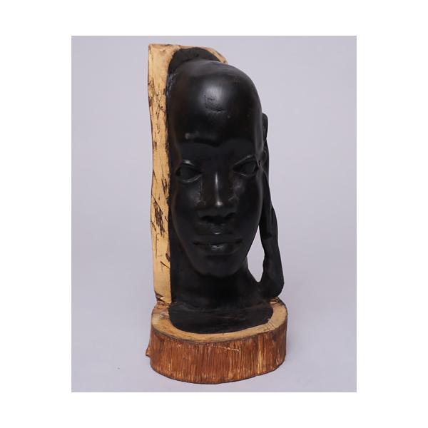 原産国:タンザニアサイズ:高さ約20cm東アフリカのマコンデ族に受け継がれる木彫技術によって生み出されたヘッドスカルプチャーです。着色に頼らず、木そのものが持つ芯の深い色合いと、外皮に近い明るい部分とのコントラストを活かすことで、静かな表情...