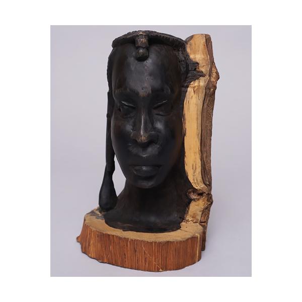 原産国:タンザニアサイズ:高さ約19cm東アフリカのマコンデ族に受け継がれる木彫技術によって生み出されたヘッドスカルプチャーです。着色に頼らず、木そのものが持つ芯の深い色合いと、外皮に近い明るい部分とのコントラストを活かすことで、静かな表情...