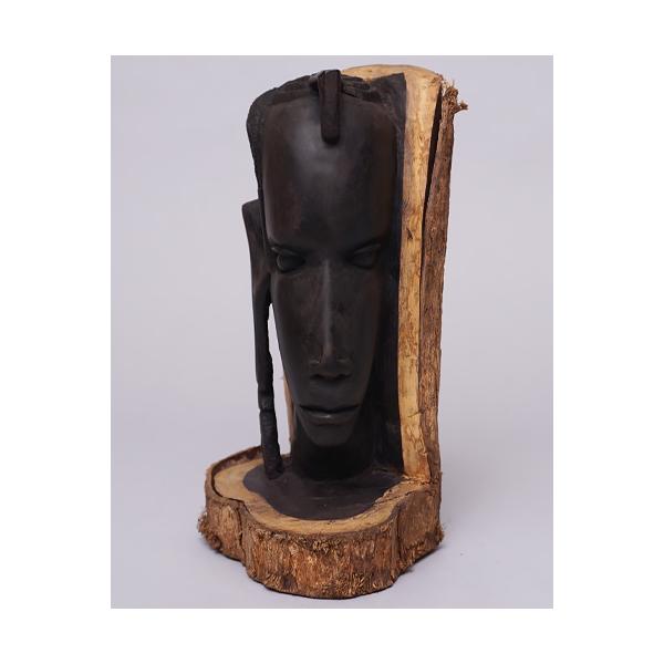 原産国:タンザニアサイズ:高さ約23cm東アフリカのマコンデ族に受け継がれる木彫技術によって生み出されたヘッドスカルプチャーです。着色に頼らず、木そのものが持つ芯の深い色合いと、外皮に近い明るい部分とのコントラストを活かすことで、静かな表情...