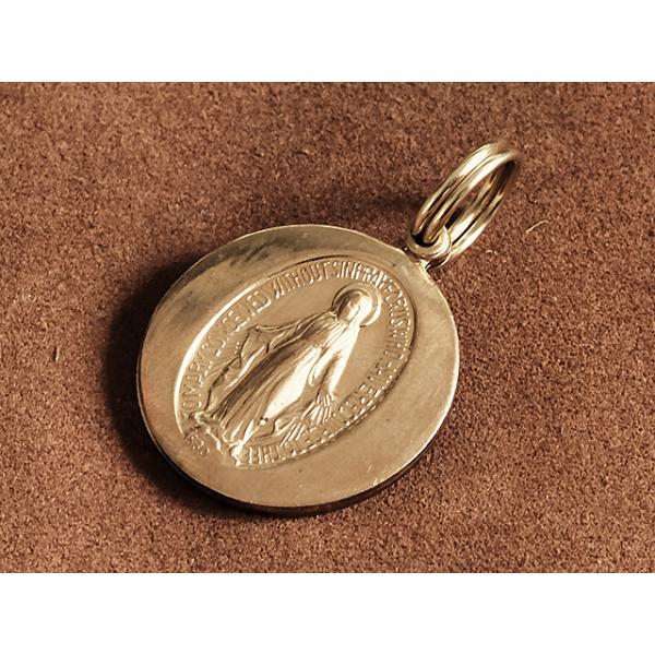 真鍮で作られたのペンダントトップです。聖母マリアがデザインされております。2枚仕立てとなっており、1枚目をスライドすると2枚が出てきます。2枚目には英文で主の祈り（Lord's Prayer）が記載されています。真鍮二重リングを装着していま...