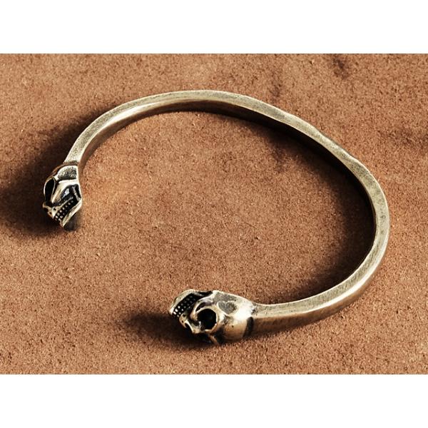 真鍮のブレスレットです。先端にはスカルが両箇所デザインされています。細身のデザインでスタイルや性別を問わない、ベーシックさが魅力です。線は平押しタイプとなります。※開口部は多少のサイズ変更が可能です。サイズ内径（開口含まず）/15cm開口/...