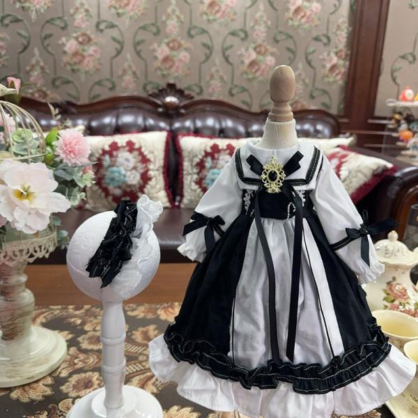 上品でクラシカルな雰囲気が漂う、BJDドール用のロリータ風ワンピース＆ヘッドドレスセットです。ホワイトを基調に、ブラックのリボンとフリルをあしらった上品な配色。胸元にはアンティーク調のブローチ飾りを施し、気品と存在感を引き立てます。袖口のリ...