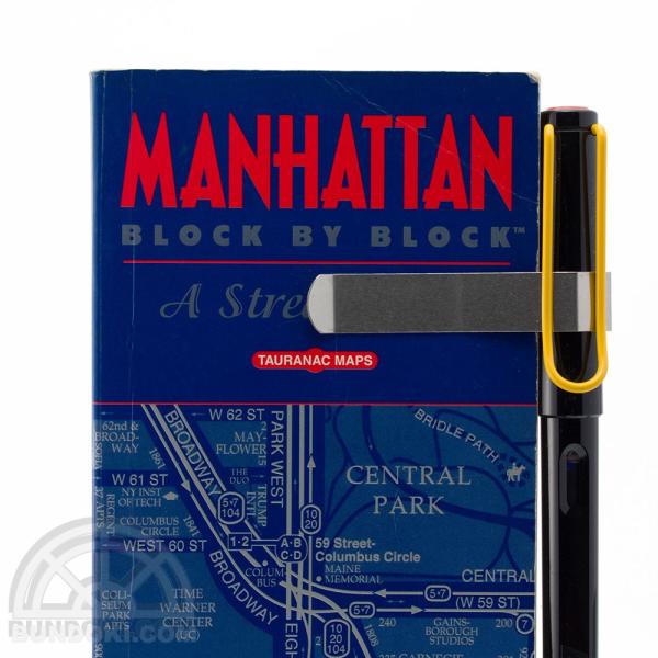 マネークリップを大きくしたような形状のステンレス製のシンプルなクリップです。 手帳やノート、パスポートなどと一緒にペンを挟んで持ち運びができる便利アイテムです。