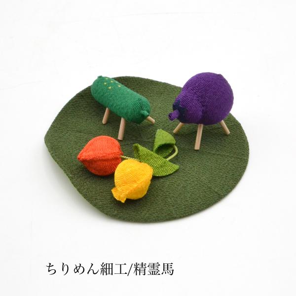 お盆飾りの精霊馬をちりめん細工にしたお品。しかもミニサイズですのでとっても可愛らしさがUP！蓮の上にコロンとナス、キュウリ、ホオズキがのっています。■サイズ　約幅10×奥行き10×高さ３.５cm■素材　レーヨンちりめん■送料無料■箱をコンパ...