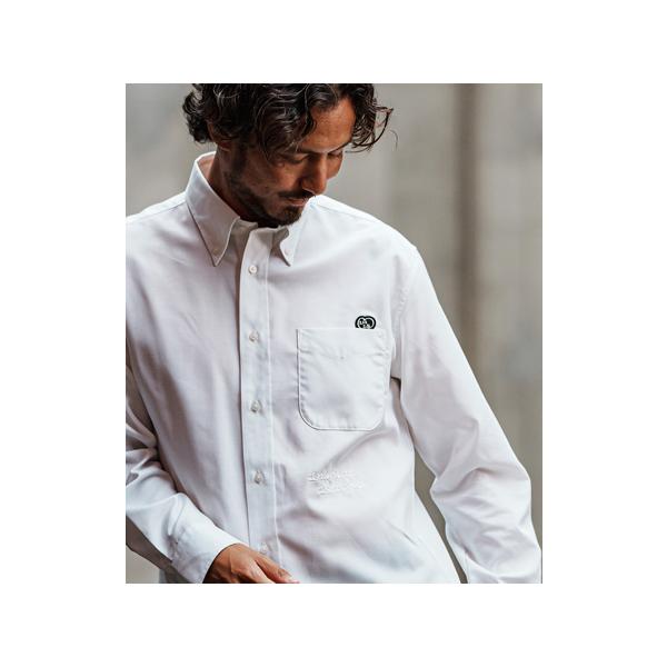 181cmのモデルがMサイズを着用。オーソドックスなボタンダウンシャツに、フロントの筆記体ロゴがリラックス感を出している注目のアイテム。ロゴは同色の刺繍になっているので、オンでもオフでも幅広いシーンで重宝します。胸ポケットに見え隠れするハー...