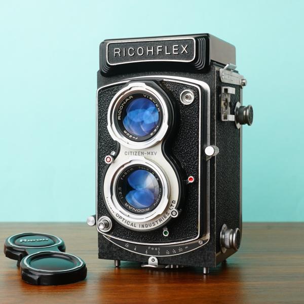 1956年発売。中判フィルム（120サイズ）を使用し、6×6cmの正方形写真（ましかく写真）が楽しめる二眼レフカメラ「RICOHFLEX NEW DIA」です。左右のレバーをシーソーのように動かしてピントを調整する、リコー独自のスタイルが非...