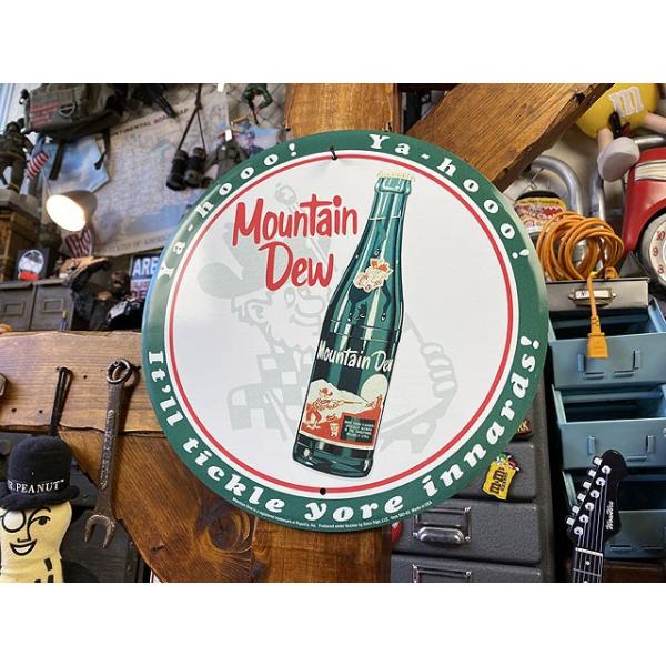 レトロなアメリカを感じるソーダドリンク、マウンテンデューのブリキ看板です。コミカルなカウボーイのキャラが、いかにも昔っぽくてイイ感じ！当時はこんな愛嬌満点のキャラが、ボトルにもデザインされていたんです。ラウンドタイプなので、柱のアクセントや...