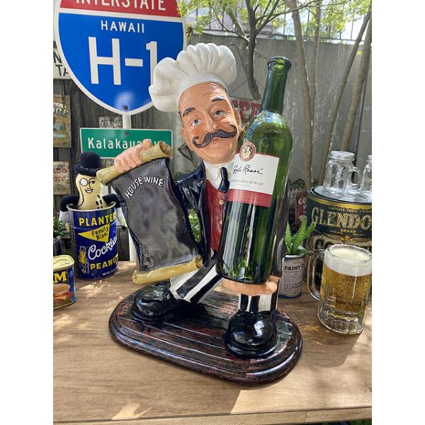 立派な口ひげをしたシェフが「本日のおすすめワイン」を紹介するという・・・・ユニークなオブジェがこちら！実際のワインボトルをそのまま手に置ける設計になっていて、そこへ市販のボトルワインを置いてメニューに銘柄と価格、そしてオーナーのひと言を添え...