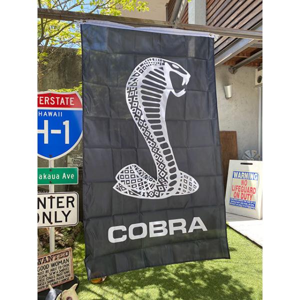 シェルビーの名を冠した特別なモデルに付けられるコブラバッジがレーシングフラッグになって登場です。アメリカのローカルサーキットなんかに足を運ぶとピットにこんなフラッグが飾られてそう！この完成されたロゴデザインは、ビッグサイズにするとどこか暴力...