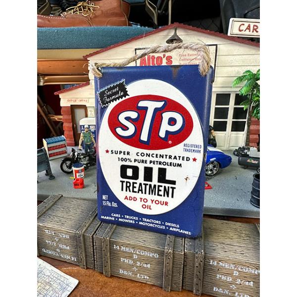 アメリカ生まれのエンジン添加剤メーカーSTPのミニサイズのハンギングサインです。STP缶に描かれてるラベルをそのまま看板にした直球ストレートなヤツ！やっぱり欲しいのはこの一番ベーシックなデザインなのよねー看板はオールドフィニッシュ加工がされ...