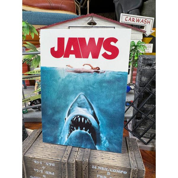 あの衝撃がポストカードになって甦る！映画史に残るサスペンスの金字塔「JAWS／ジョーズ」海水浴場の静けさを切り裂くあの不穏な旋律が聞こえてきそうな・・・・そんな名シーンがポストカードで登場です。シンプルだけどインパクトは絶大！海面下から迫り...